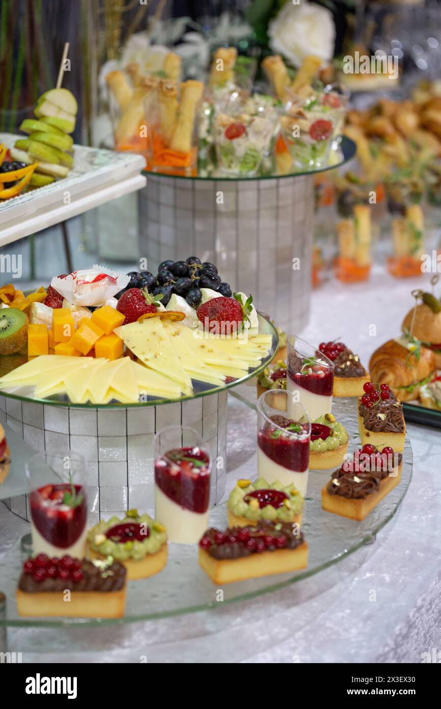 A variety of pastries, fruit, and cheese are beautifully displayed on ...