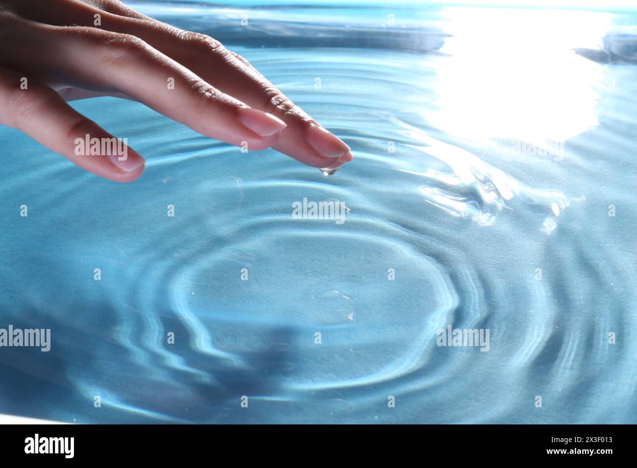Woman touching clear water, closeup. Making ripples Stock Photo - Alamy