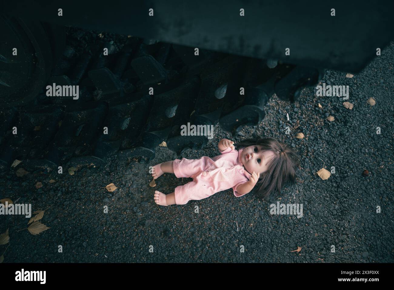 the concept of destroying childhood by war. a frightened doll and tank ...