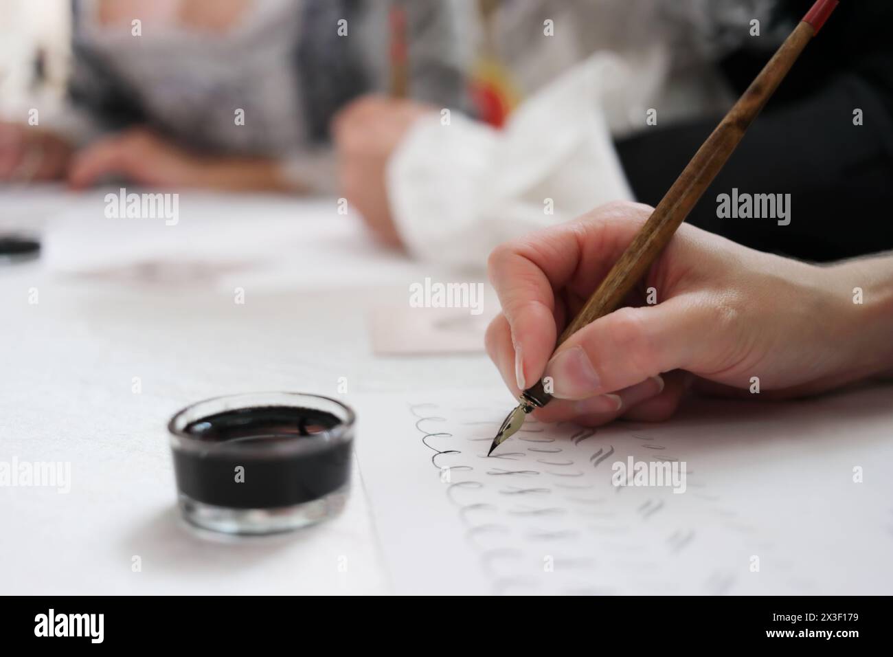 Female hand writes by feathers and ink in sample of writing, close up ...