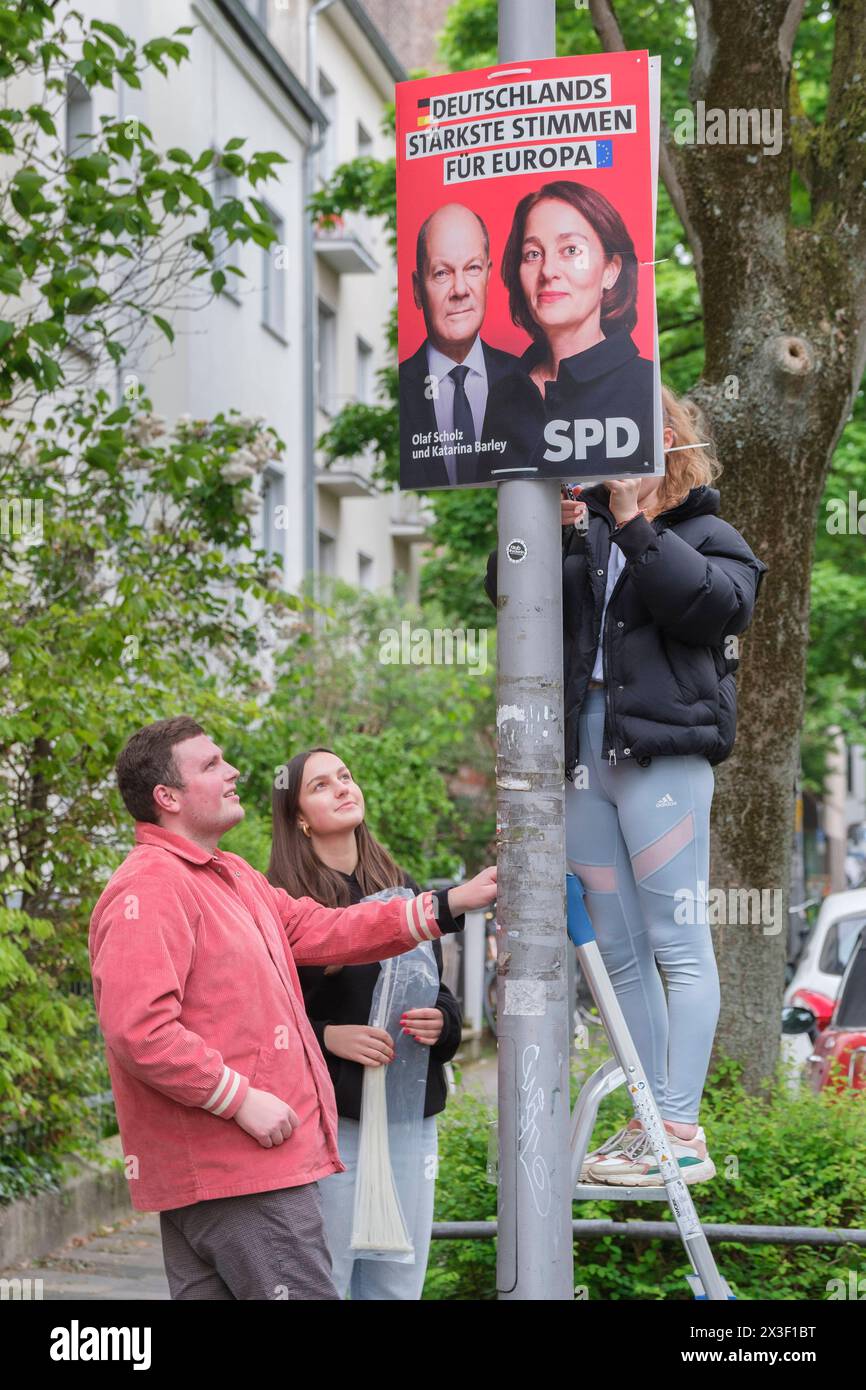 Junge Leute hängen Wahlplakate der SPD für die Europawahl 2024 mit den ...