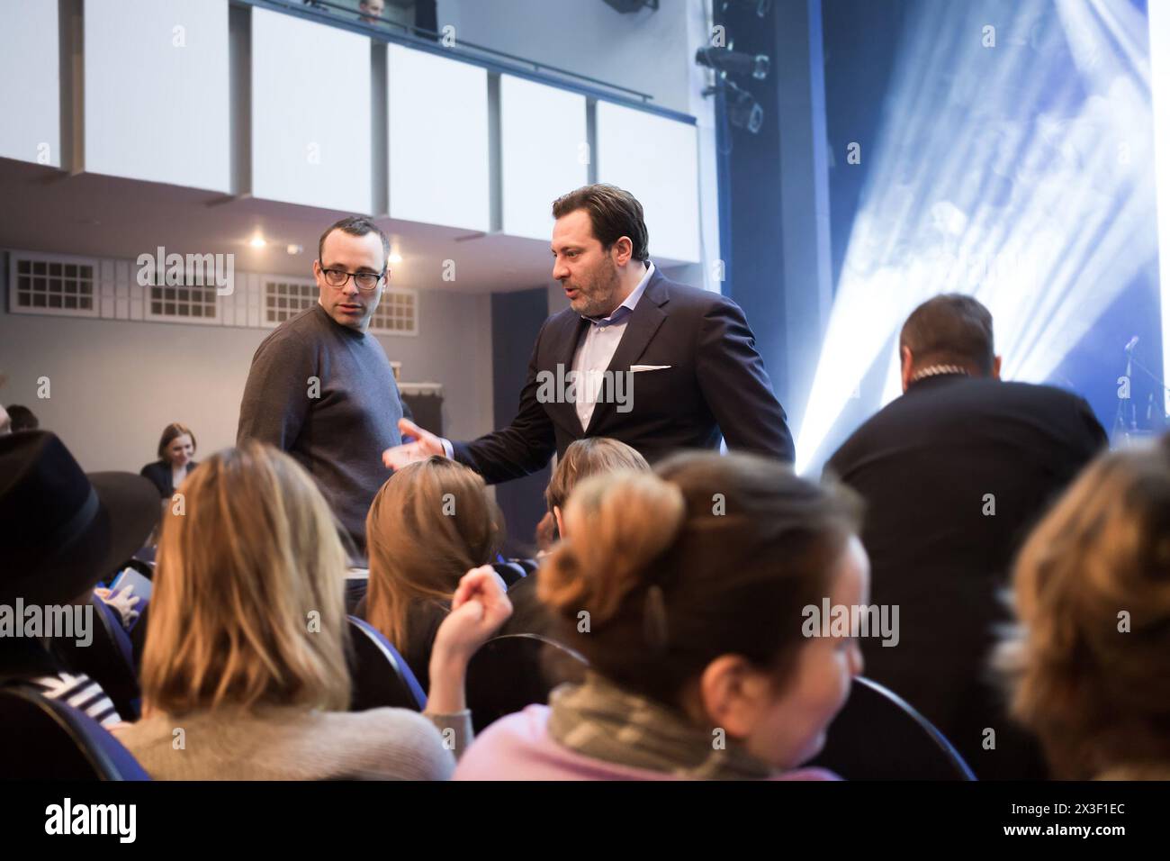RUSSIA, MOSCOW - APR 14, 2015: Two men are talking near stage and other ...