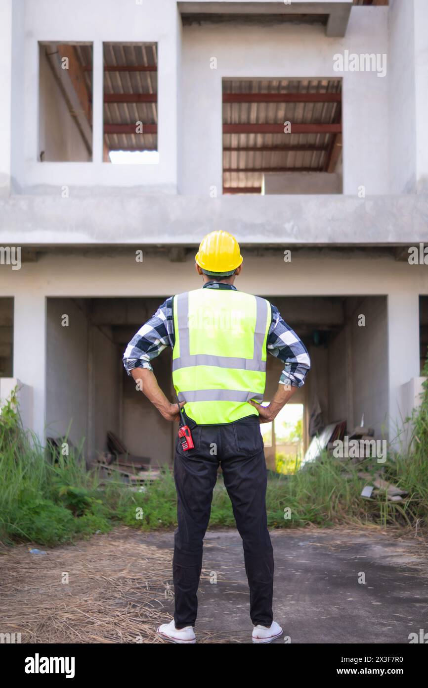 Behind the scenes foreman wearing reflective vest and hard hat inspects ...