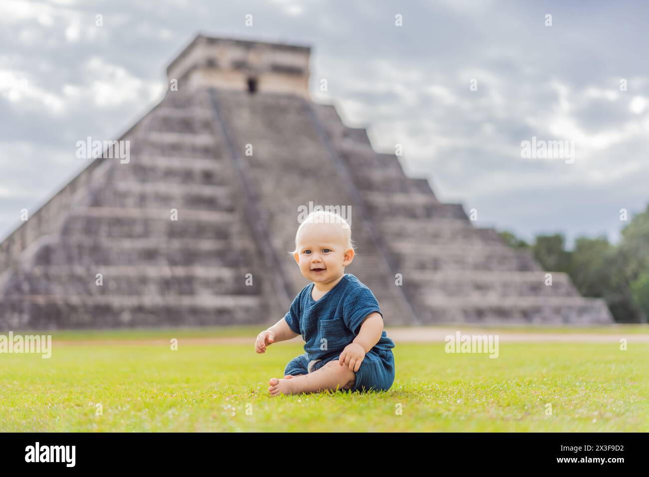 Baby traveler, tourists observing the old pyramid and temple of the ...