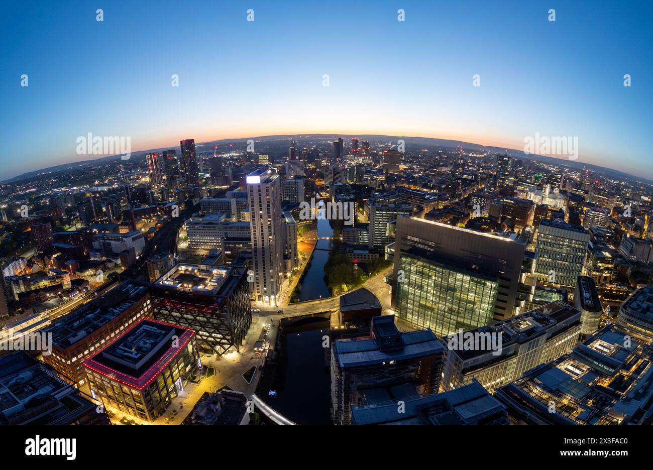The image captures an aerial view of a city with riverside buildings at ...