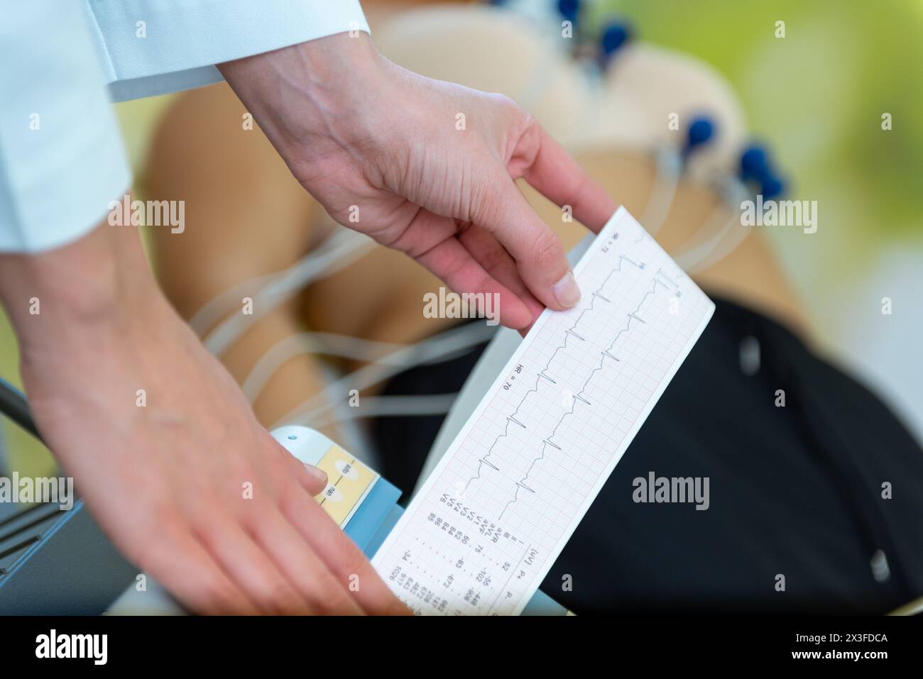 A caregiver is attentively checking a patients vitals with an EKG ...