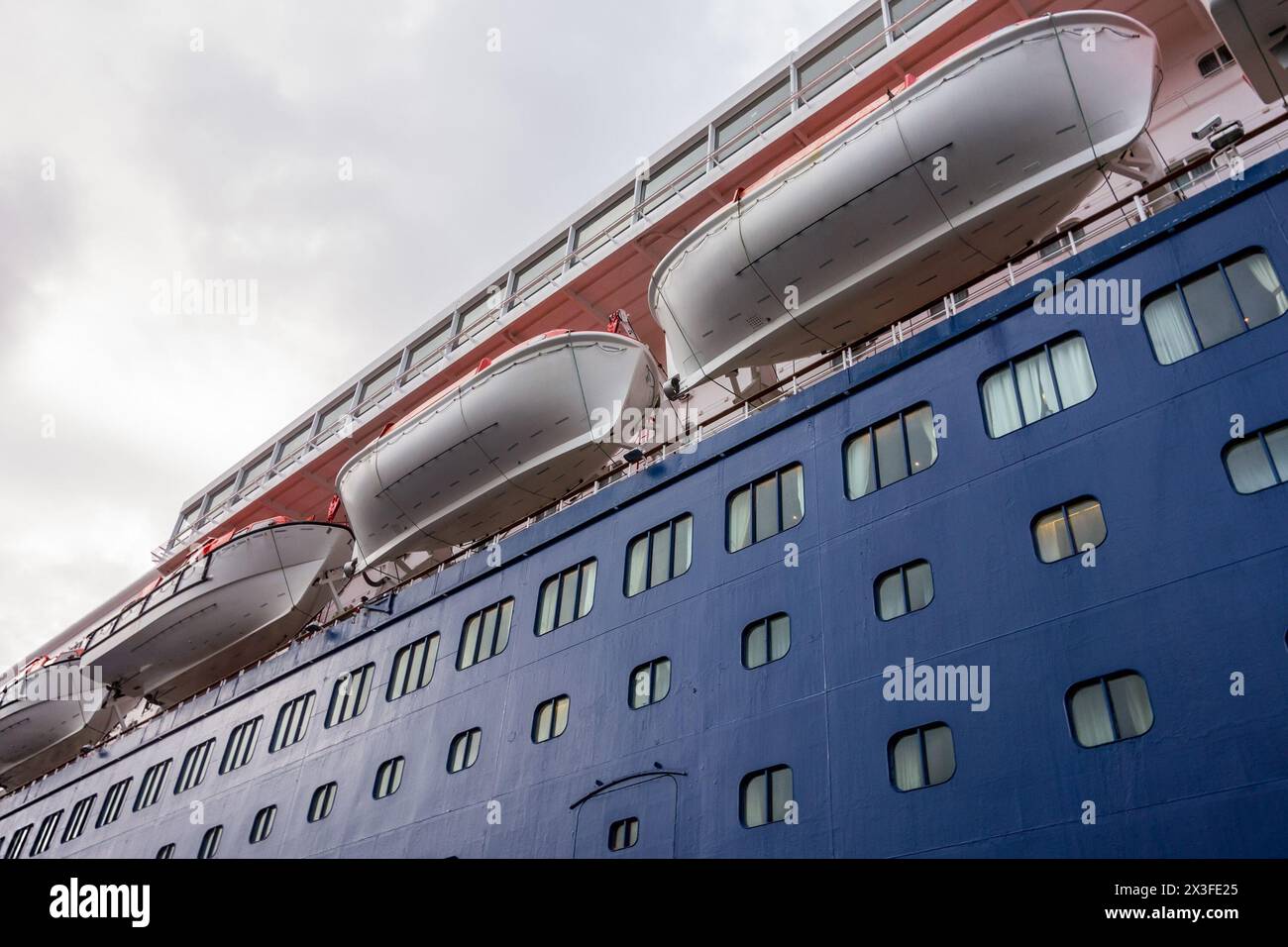 White lifeboats for life rescue on a luxury blue cruise ship with a lot ...