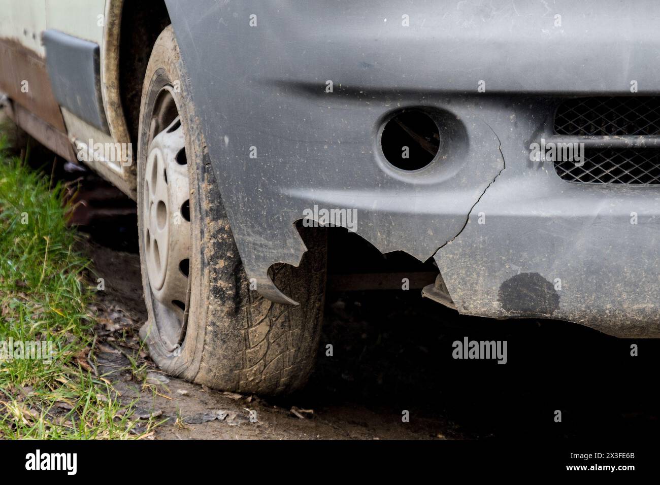 Detail of a broken plastic bumper on a white van with shallow depth of ...