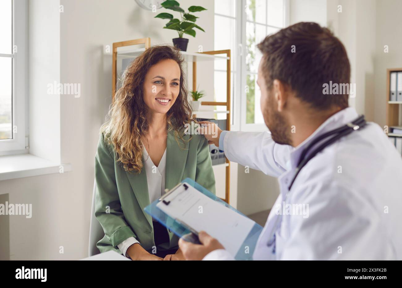 Smiling friendly doctor giving consultation a woman during medical ...