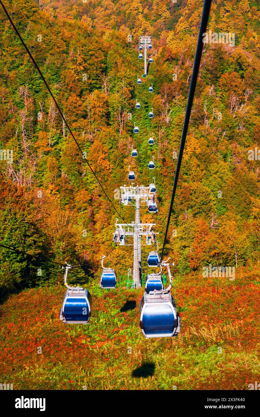 Cable car cabin rises up from Rosa Khutor village to Roza Peak mountain ...