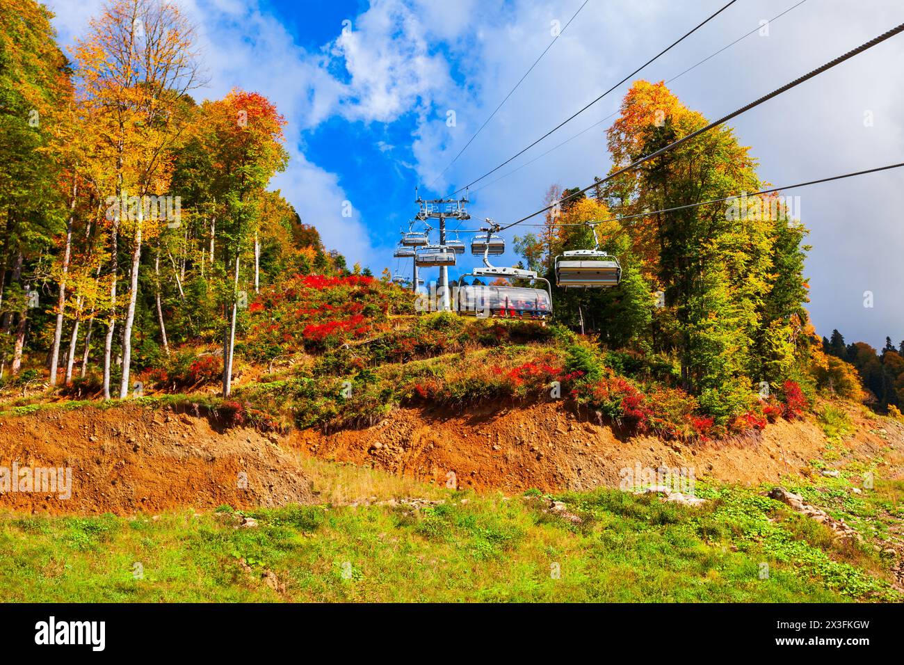 Cable car cabin rises up from Rosa Khutor village to Roza Peak mountain ...