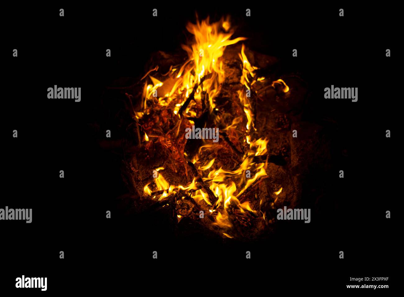 Orange and yellow bonfire flame and hot coals at night, campfire close ...