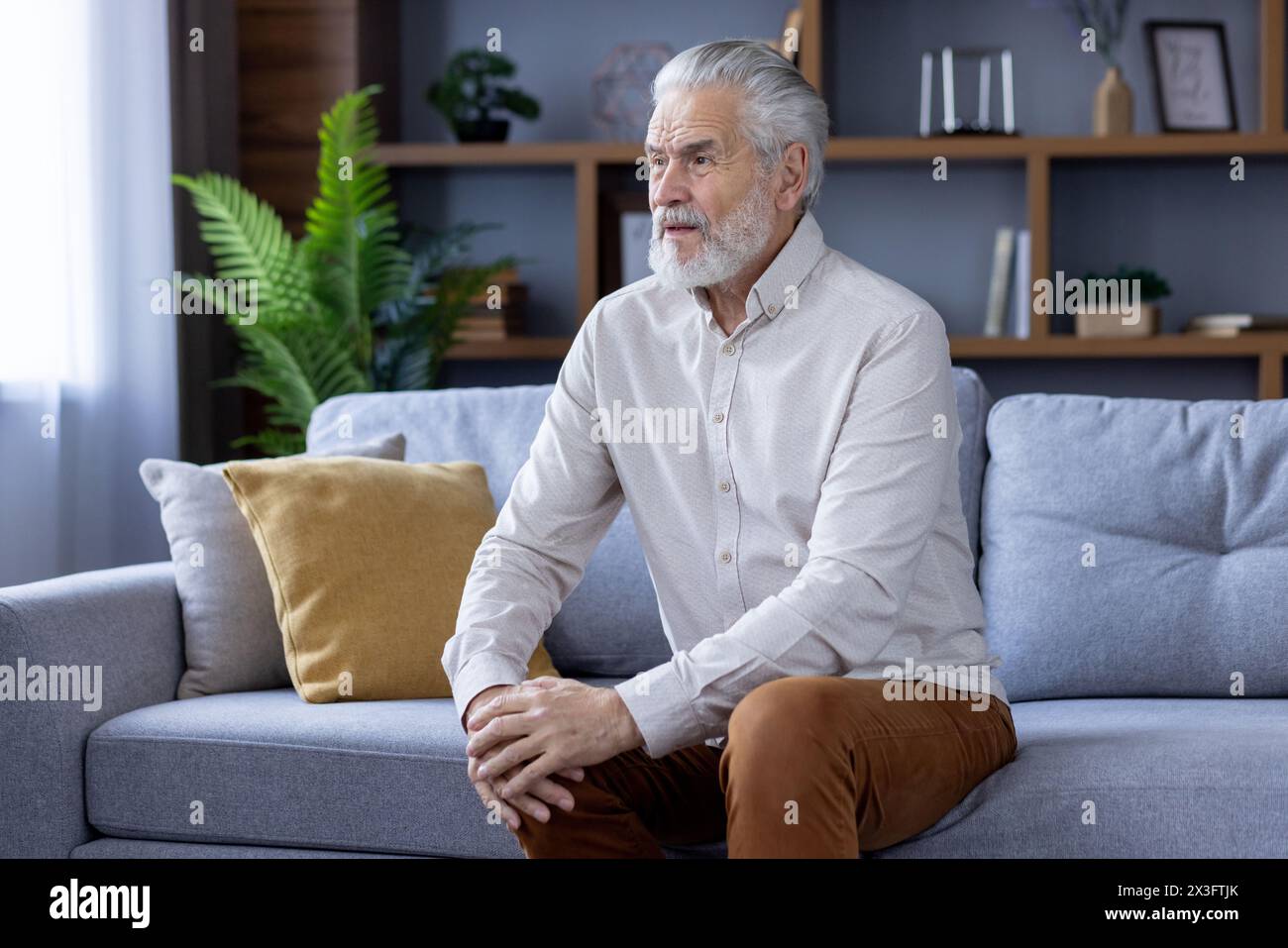 Sick senior gray-haired man suffering from pain and sprained leg ...