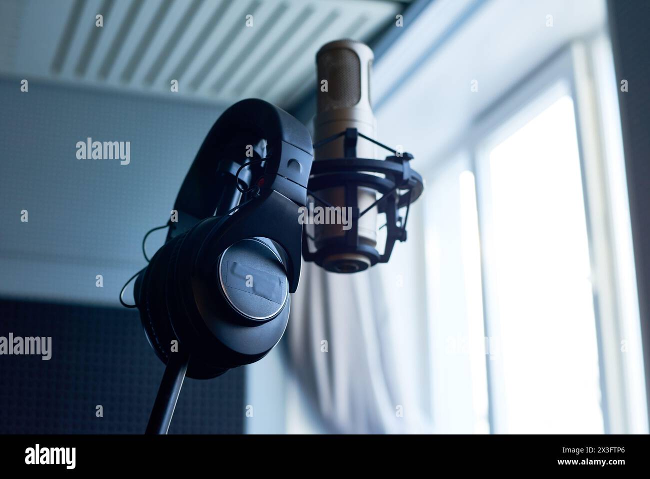 Professional condenser studio microphone and headphones hanging on ...