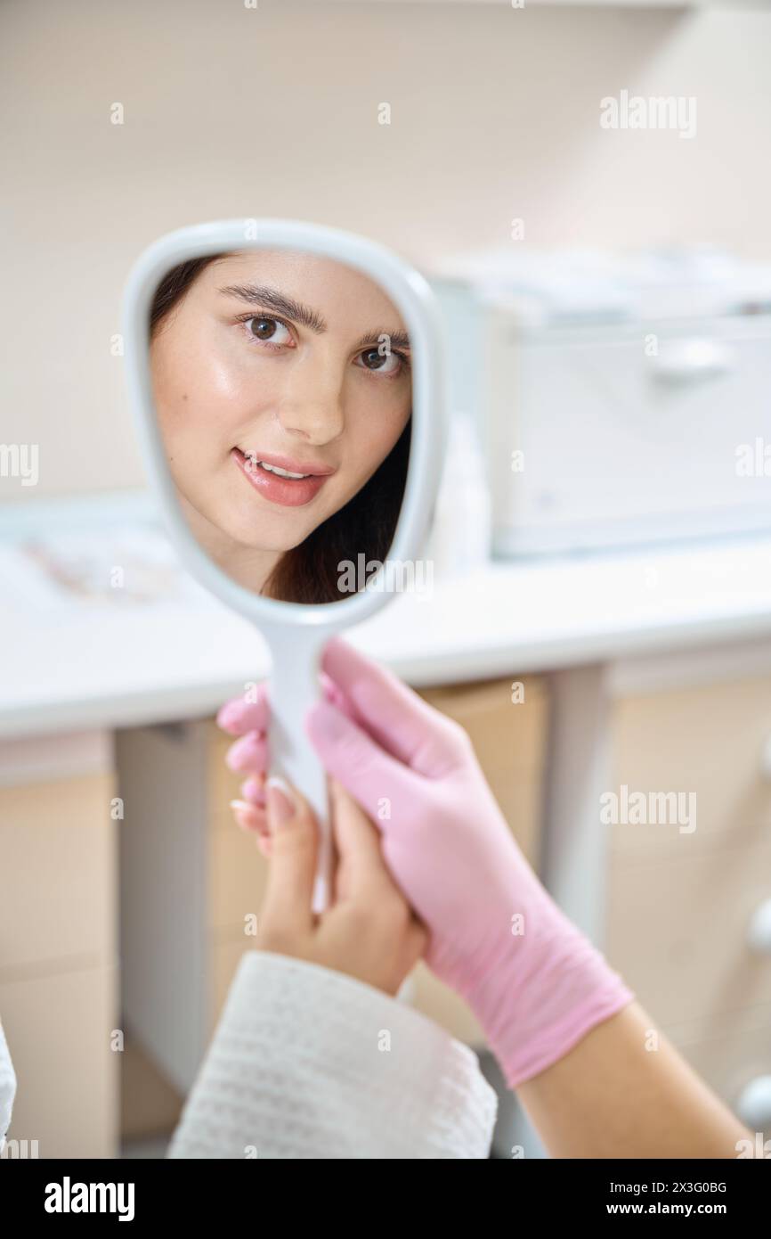 Beauty salon customer examining her face in presence of beautician ...
