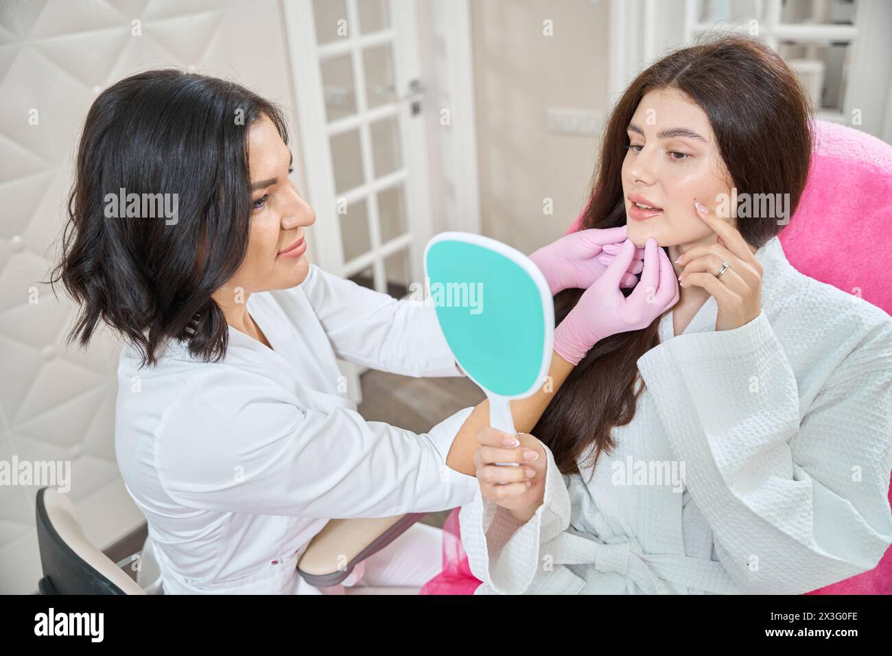 Female patient discussing with dermatologist mole removal during ...