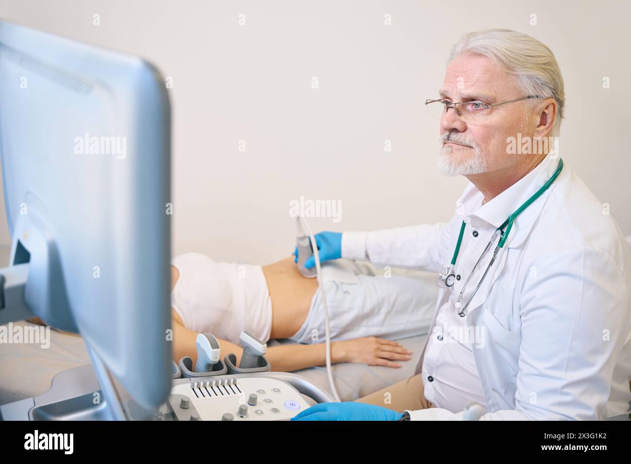 Doctor using ultrasound scan examining female patient in modern ...