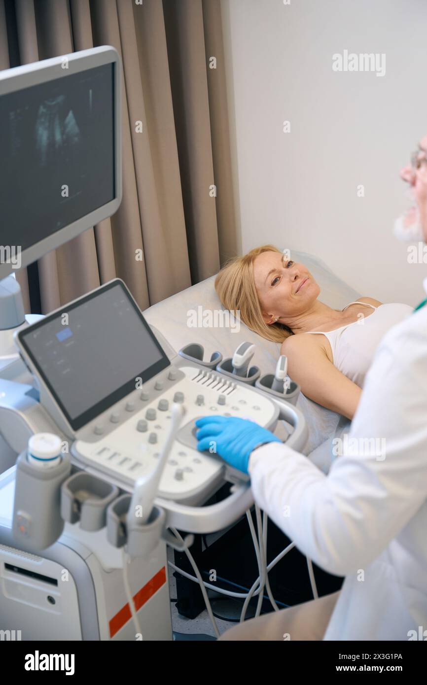 Doctor using ultrasound scan examining pretty woman Stock Photo - Alamy