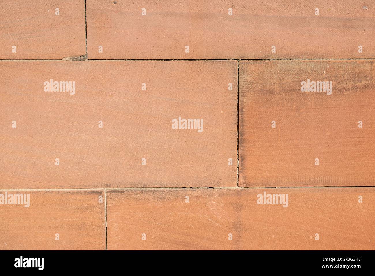 Structural stone wall of the ancient building consists of red big old ...