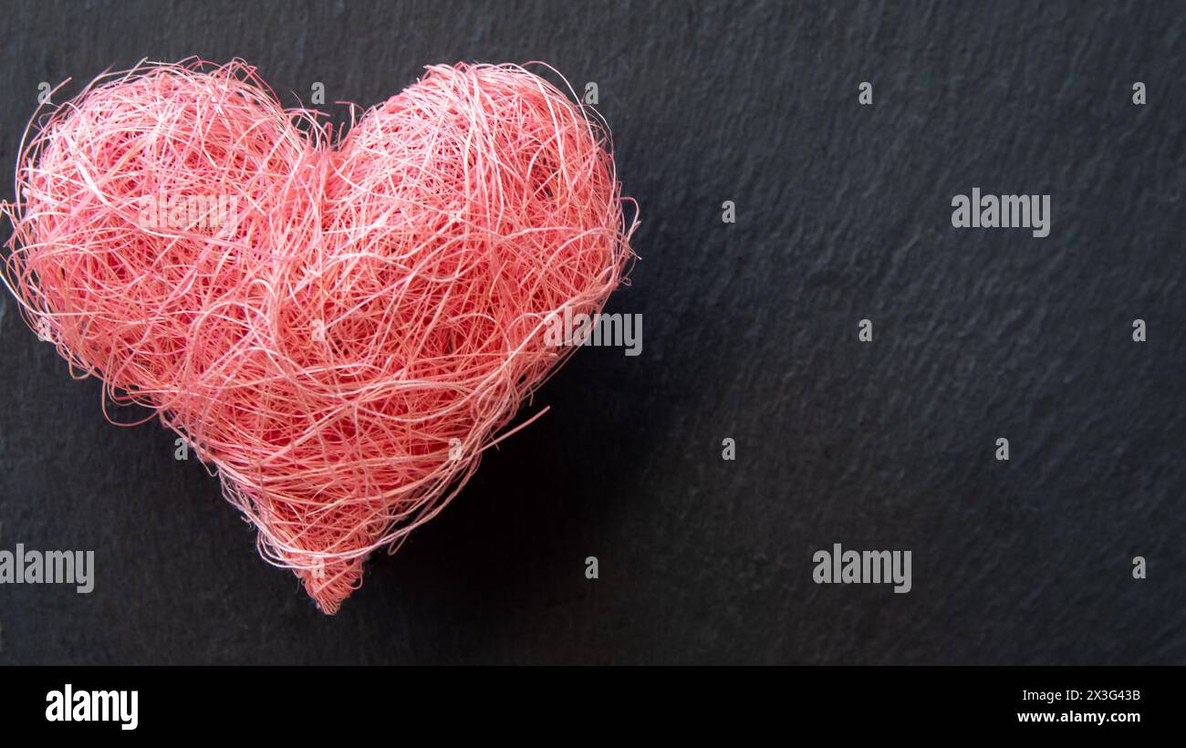 Heart shape made of material fabric on the black background with ...