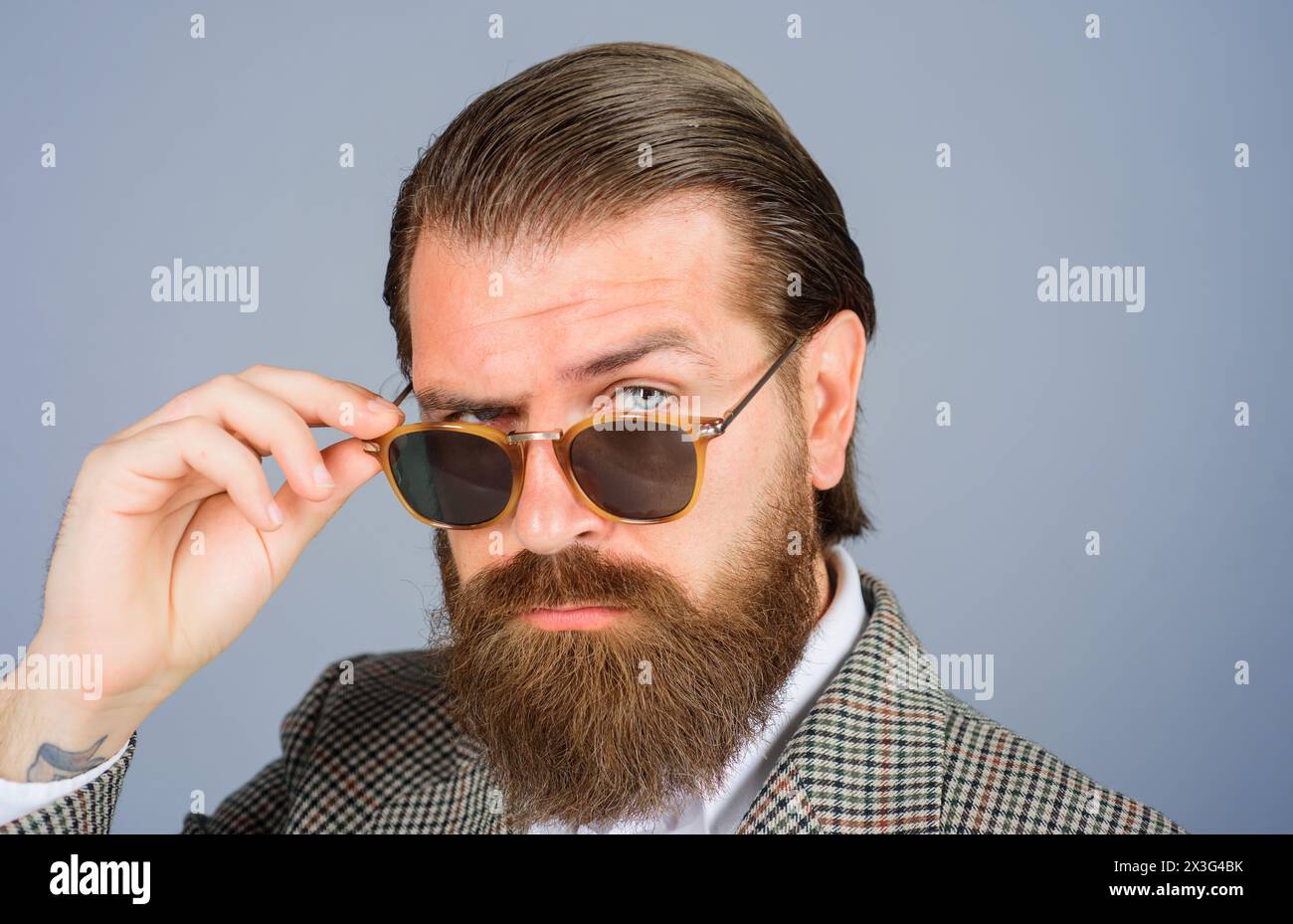 Closeup portrait of serious attractive man takes off sunglasses ...
