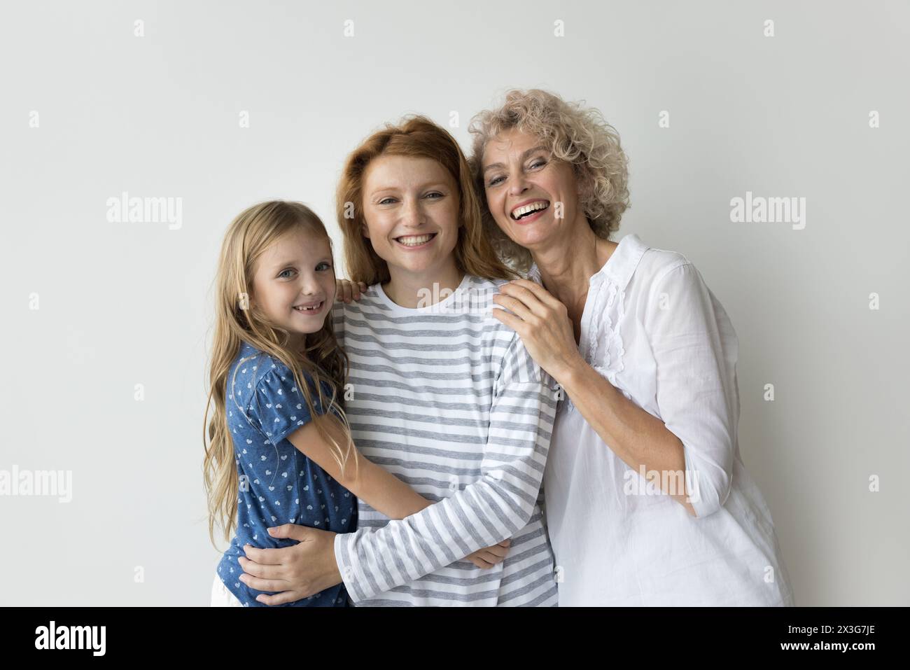 Beautiful multi-generational relatives women hugging posing on gray ...