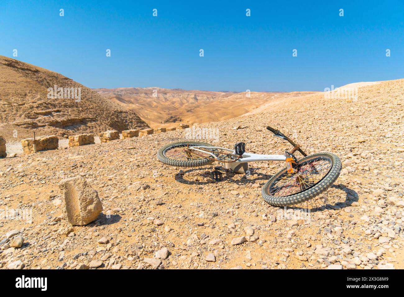 Abandoned rusty bike left in the burning sun in desert landscape of ...