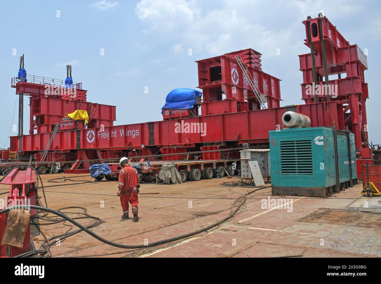 A construction worker is seen working on a barge vessel opposite the ...