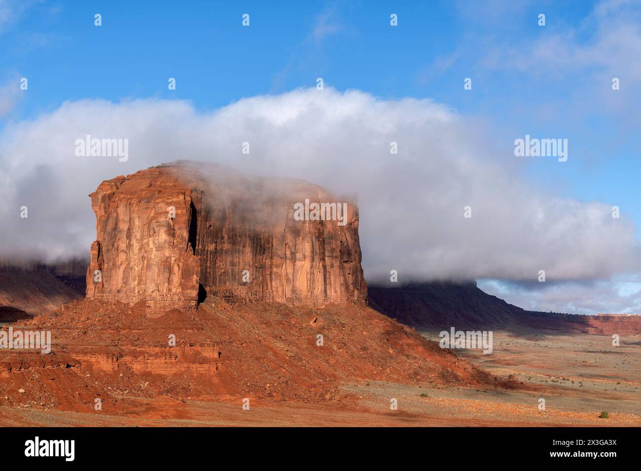 Low rainclouds hug a butte in Monument Valley's Navajo Tribal Park as ...