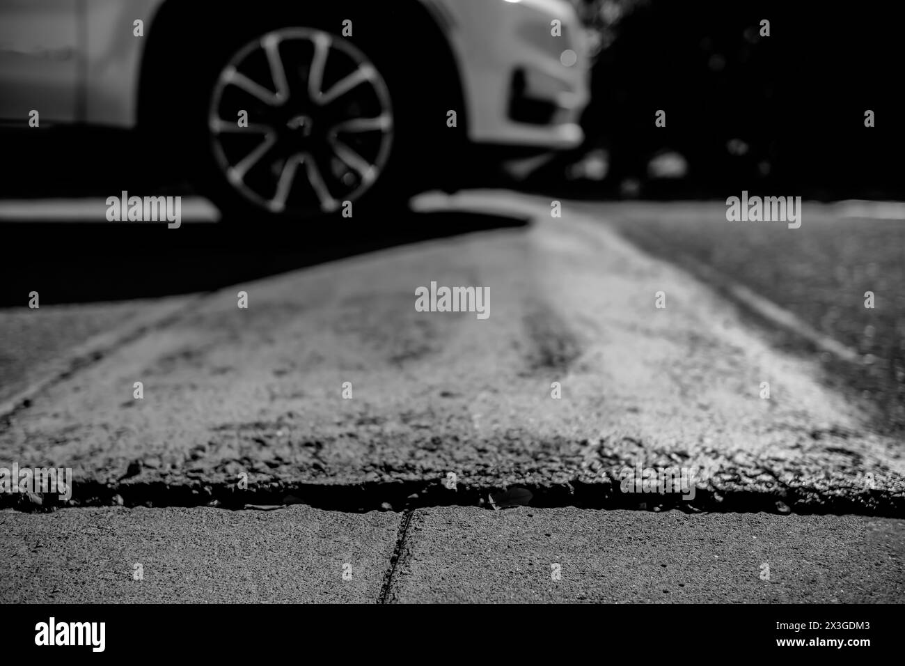 Selective focus on area in front of a speed bump with a car driving ...