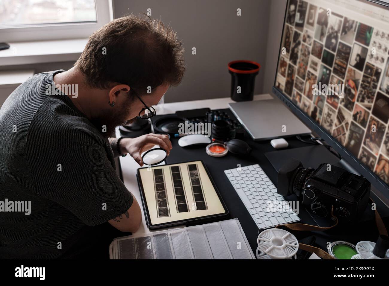 Photographer examining negatives with magnifying glass Stock Photo - Alamy