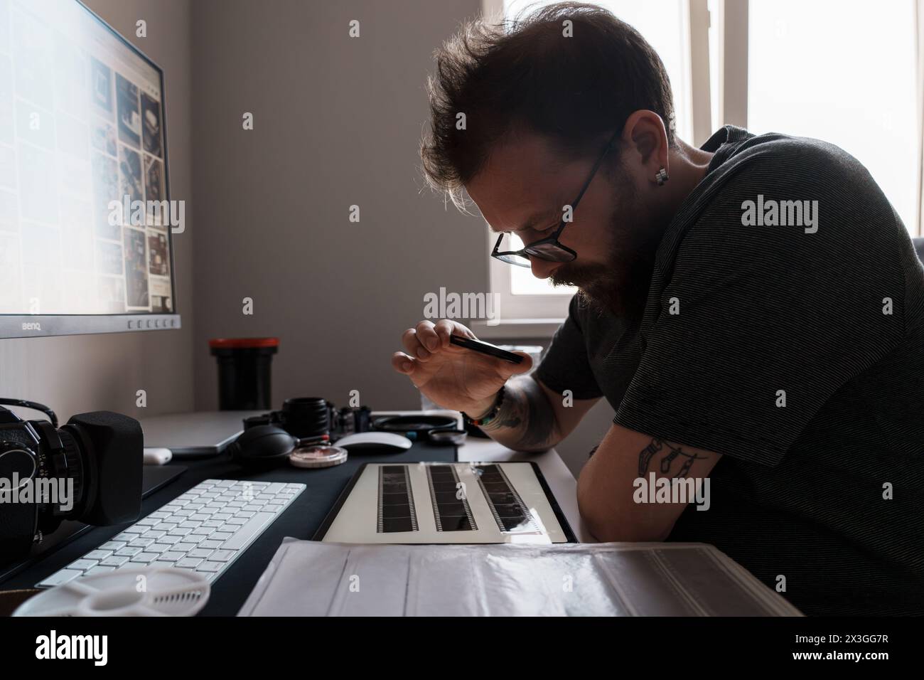 Photographer analyzing film negatives on a lightbox Stock Photo - Alamy