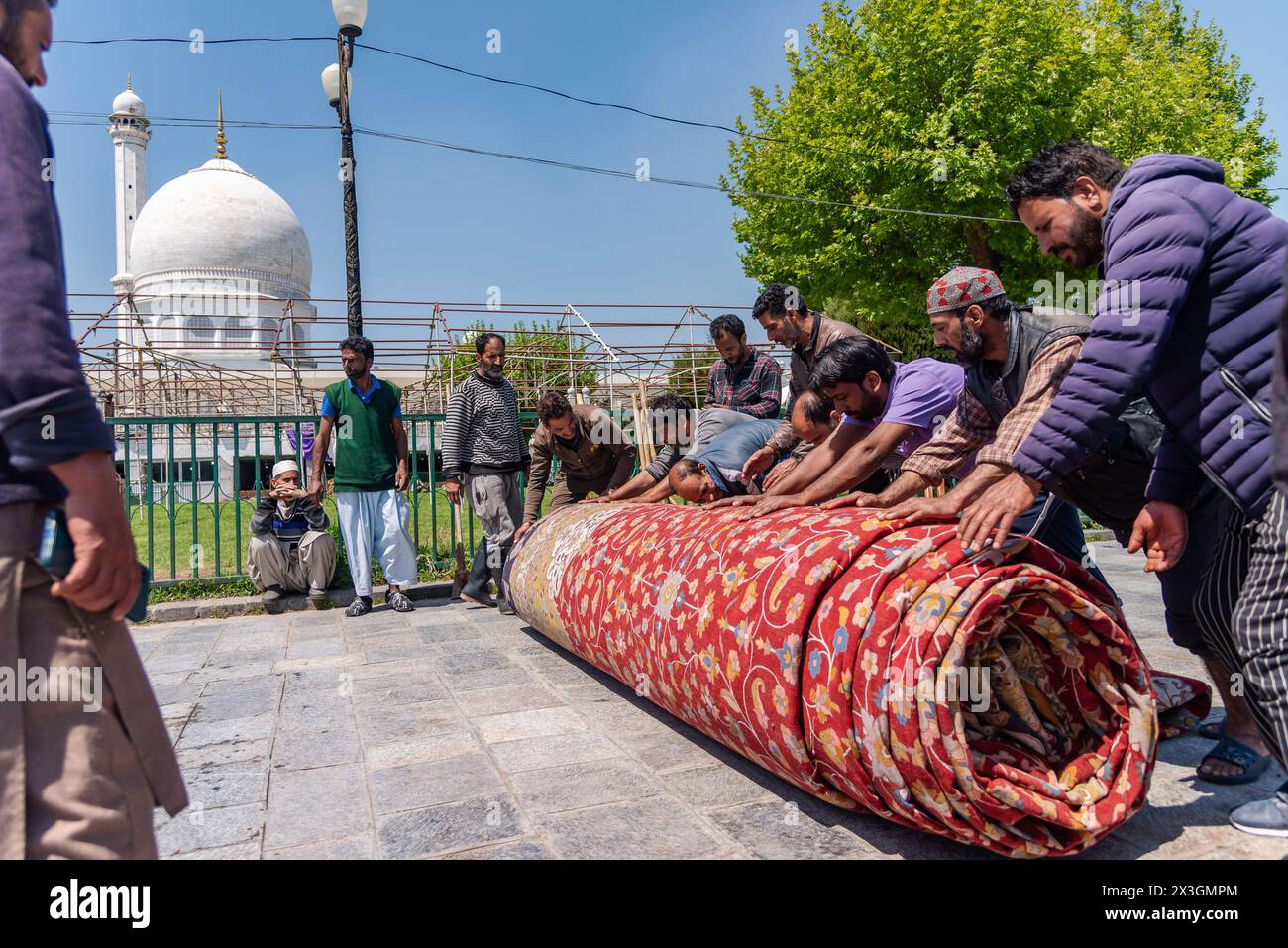 Workers are stretching the largest carpet on a path near the Hazratbal ...