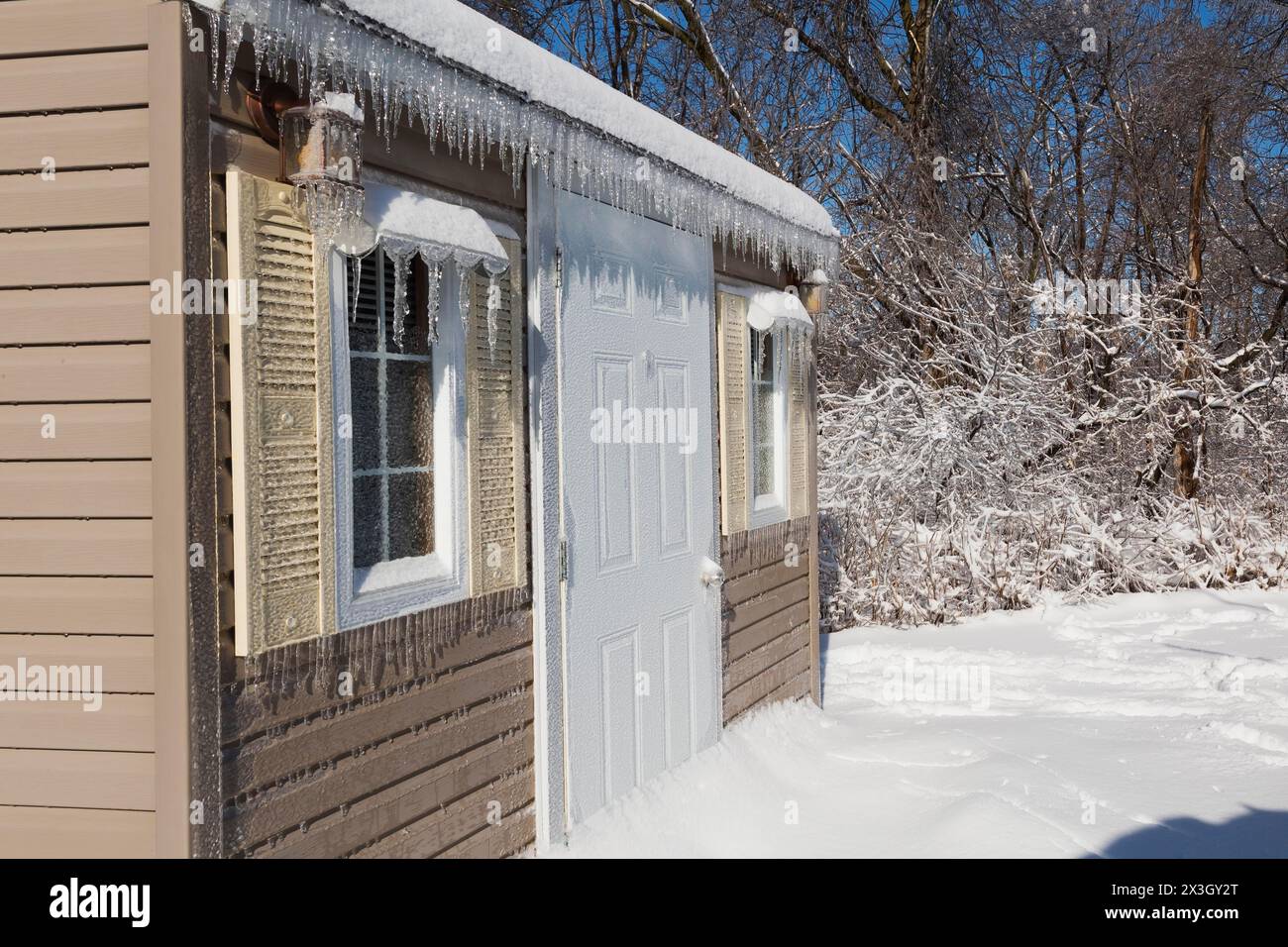 Storage shed facade covered in thick ice and snow in residential ...