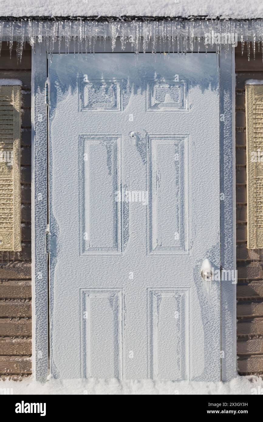 Storage shed door covered in thick ice and snow in residential backyard ...