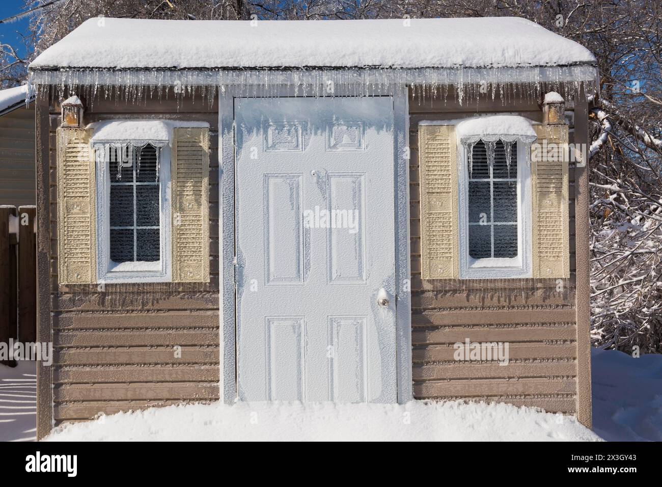Storage shed facade covered in thick ice and snow in residential ...