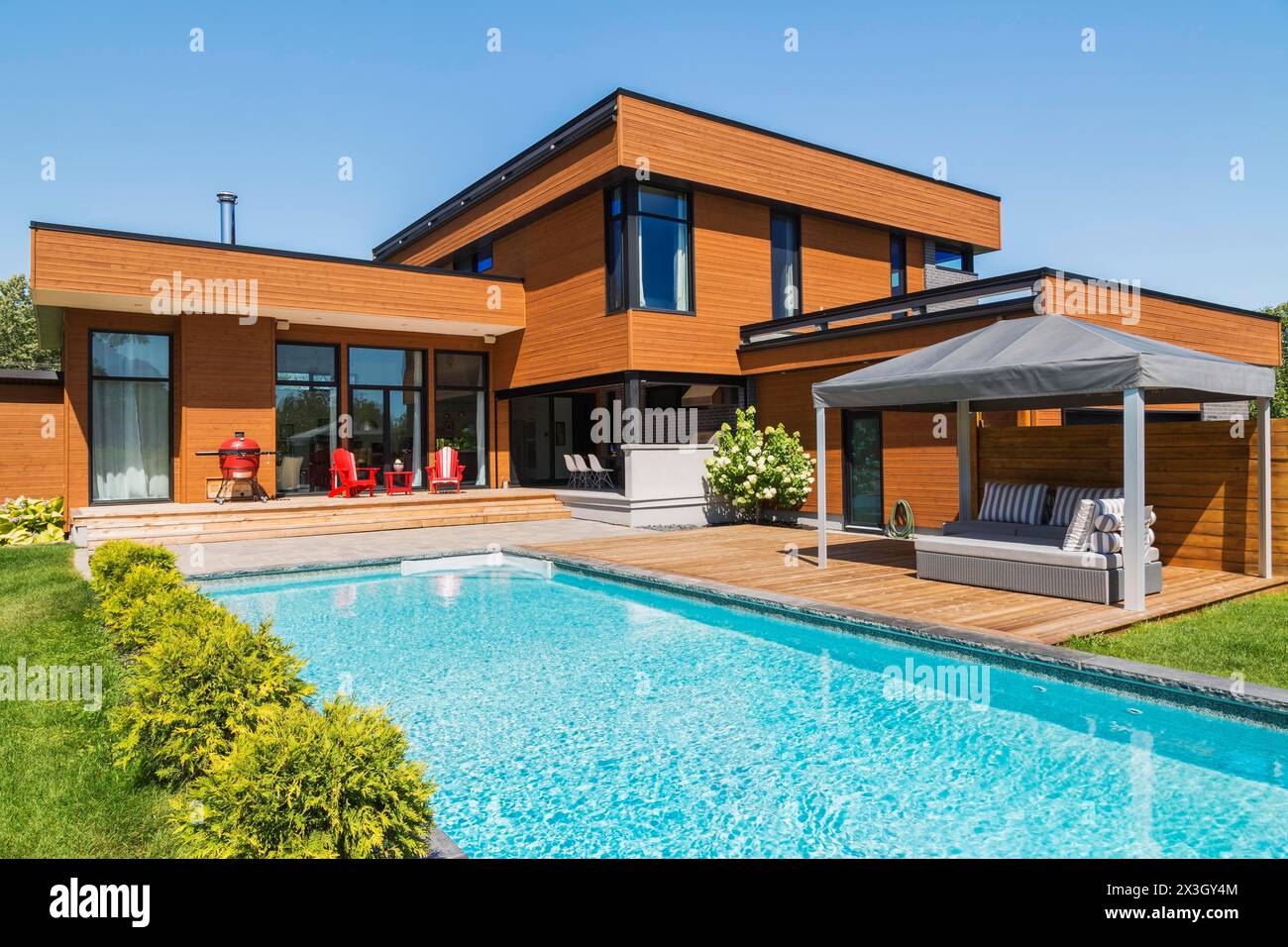Rear of modern cube style home with stained horizontal wood cladding ...
