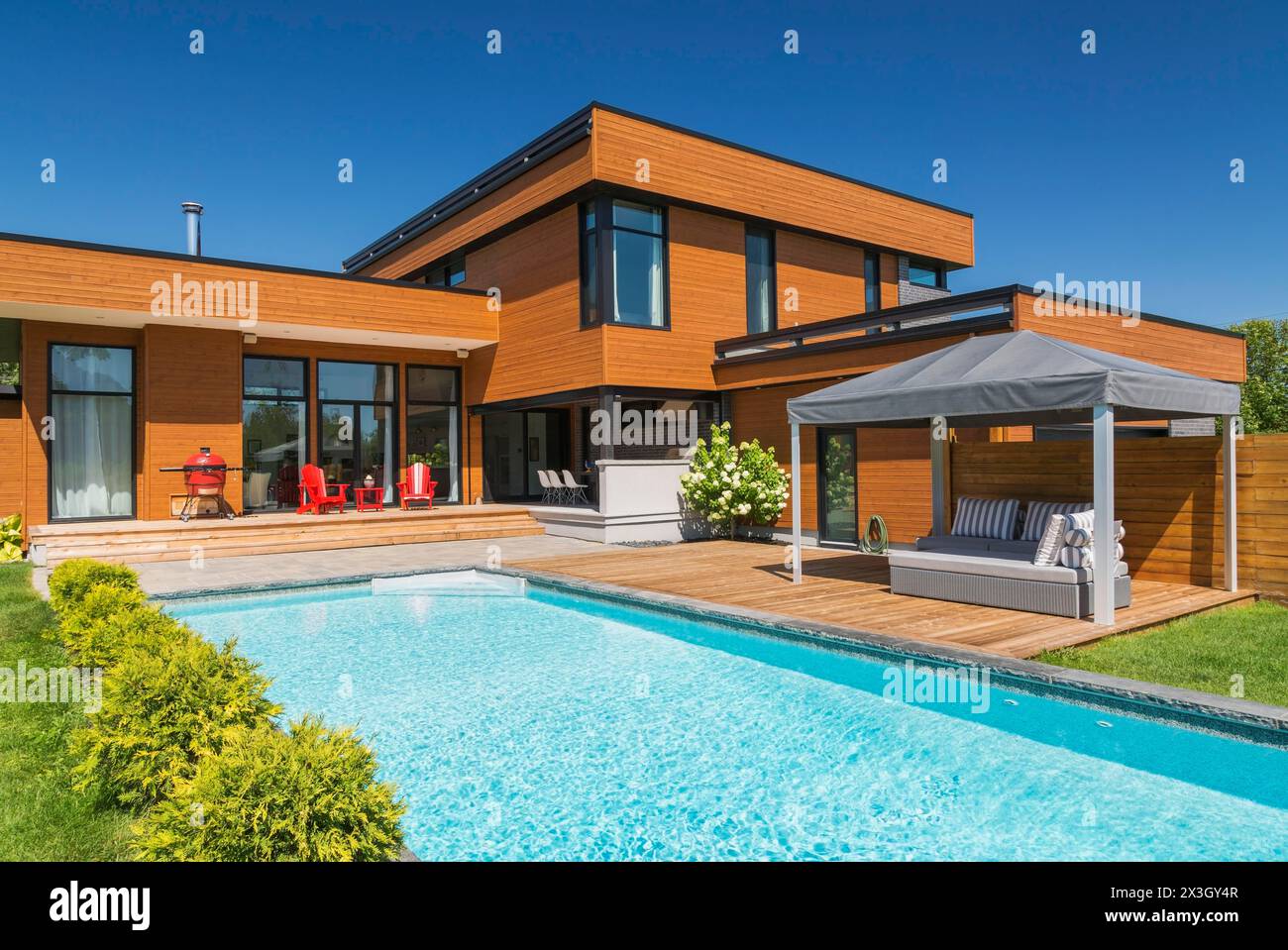 Rear of modern cube style home with stained horizontal wood cladding ...