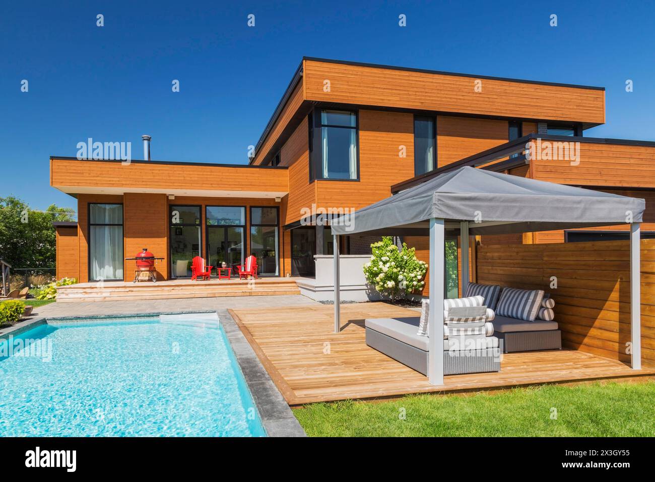 Rear of modern cube style home with stained horizontal wood cladding ...