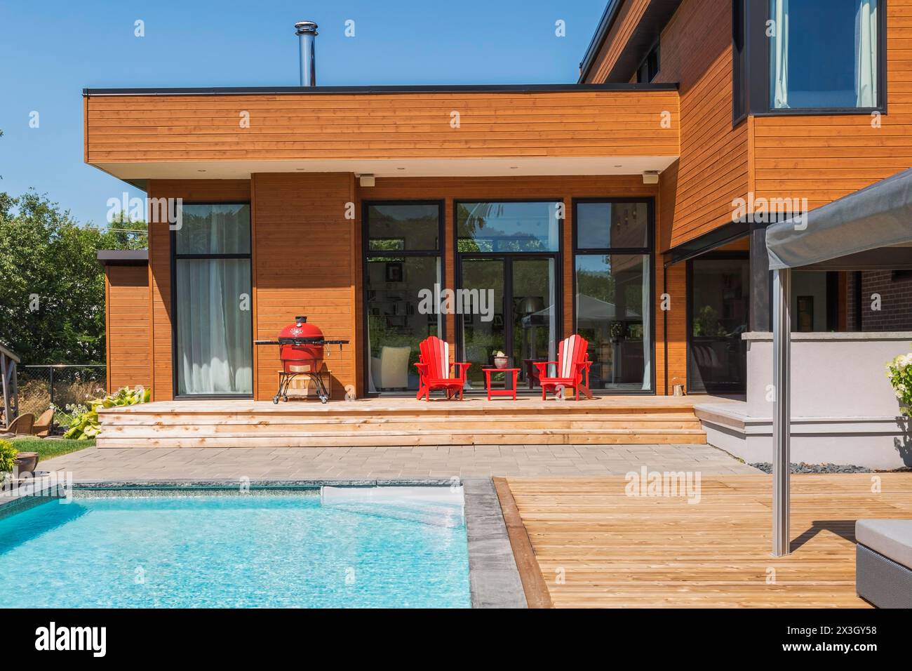 Rear of modern cube style home with stained horizontal wood cladding ...