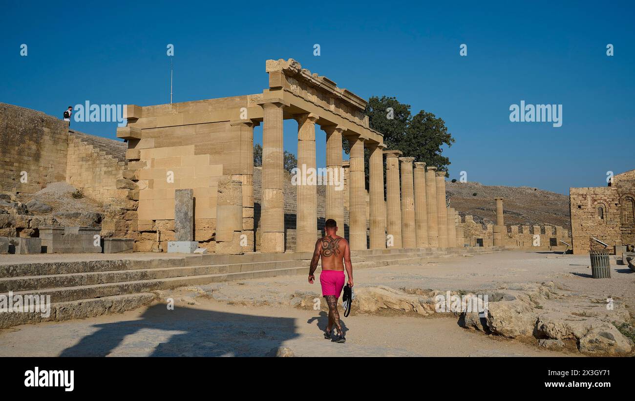 Person walking in front of the impressive ruins of an ancient temple ...