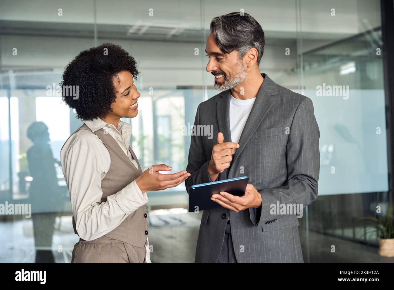 Two happy diverse professional business team people talking in office ...