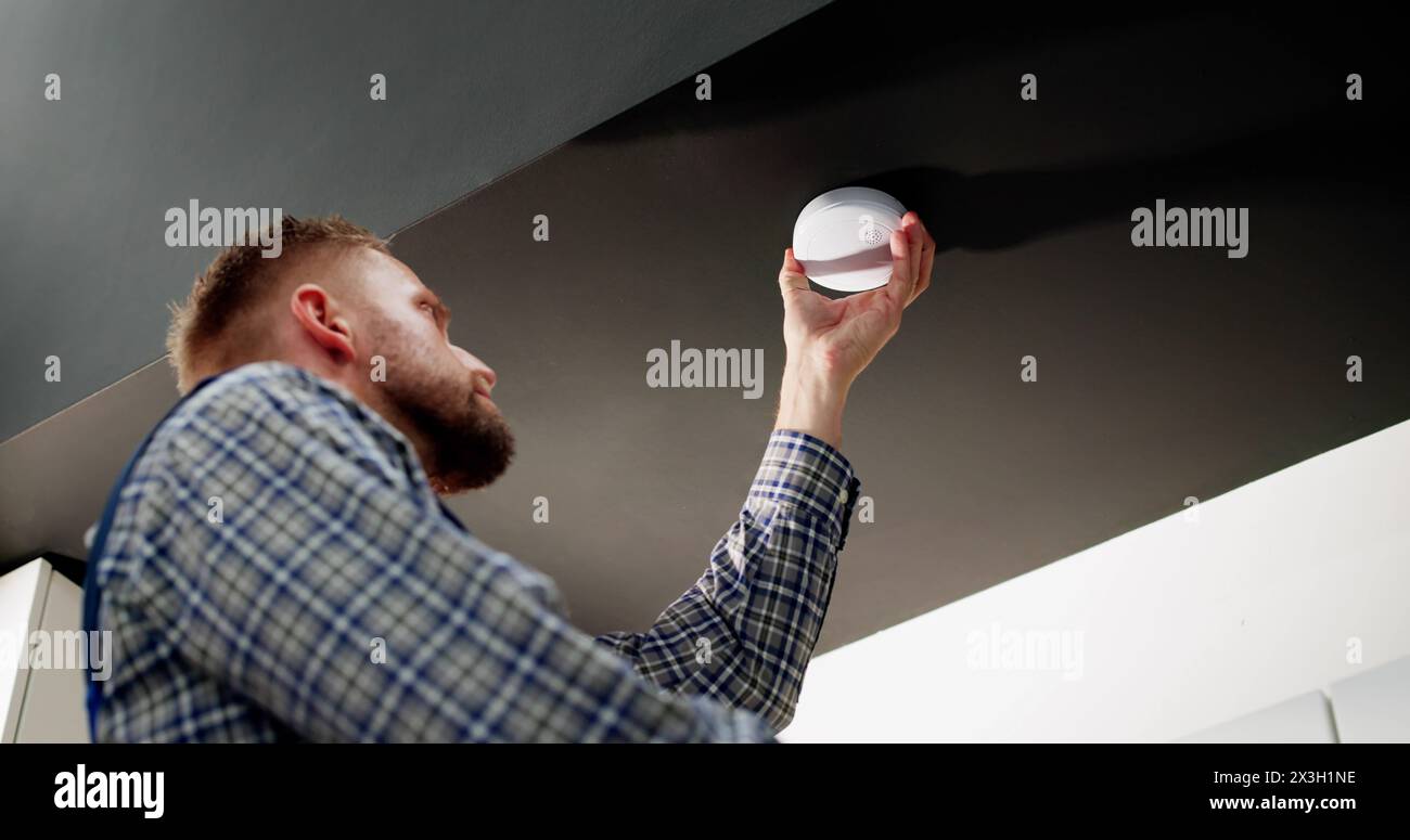 Removing Smoke Detector From Ceiling At Home Stock Photo - Alamy
