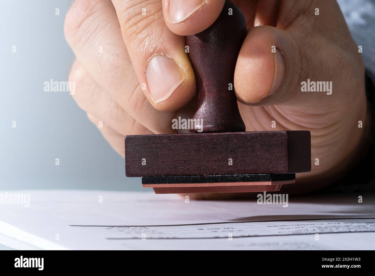 Hand holding rubber stamp for notary document seal Stock Photo - Alamy