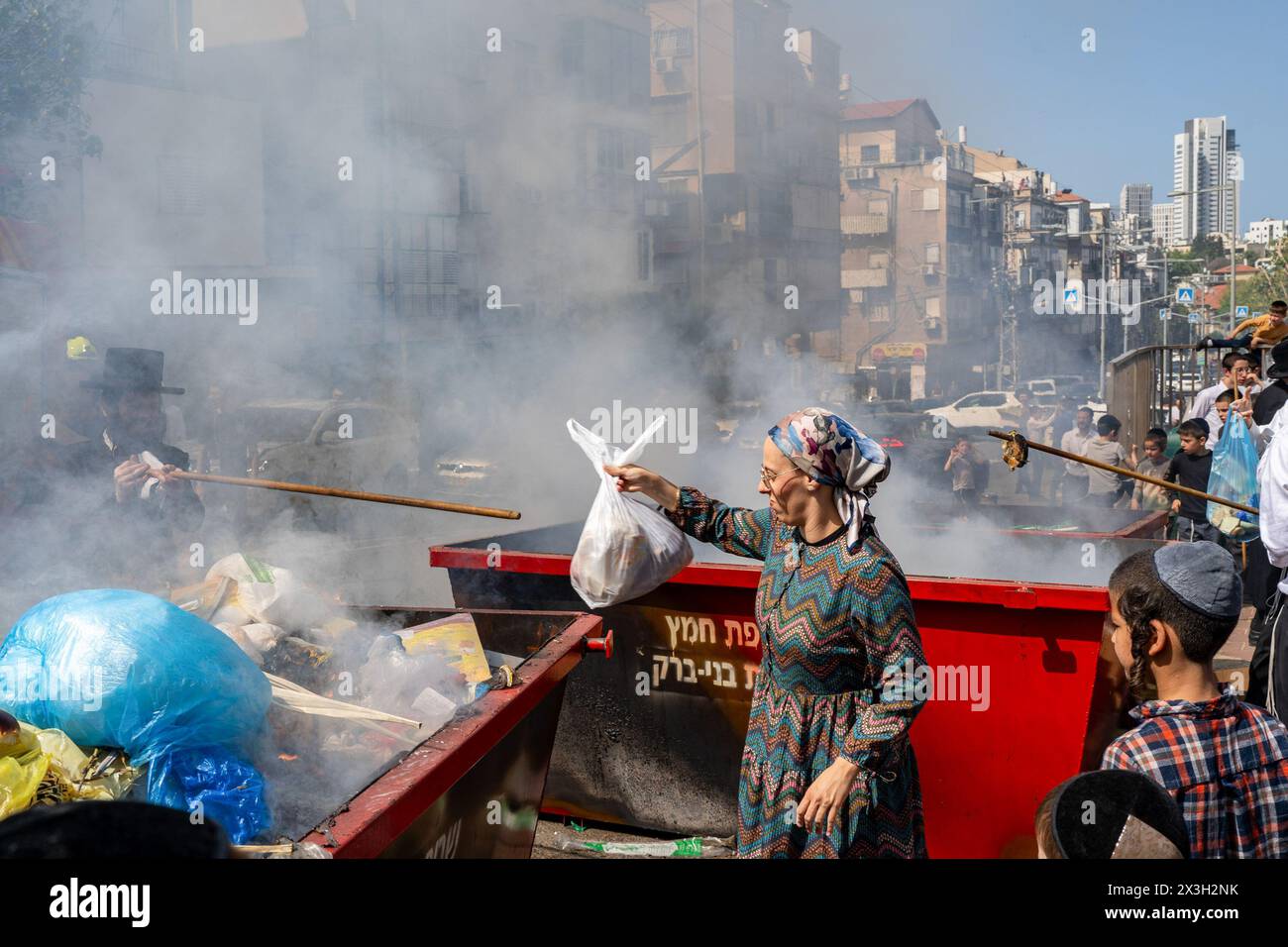A Jewish woman throws leaven into the fire during the Biur Chametz ...