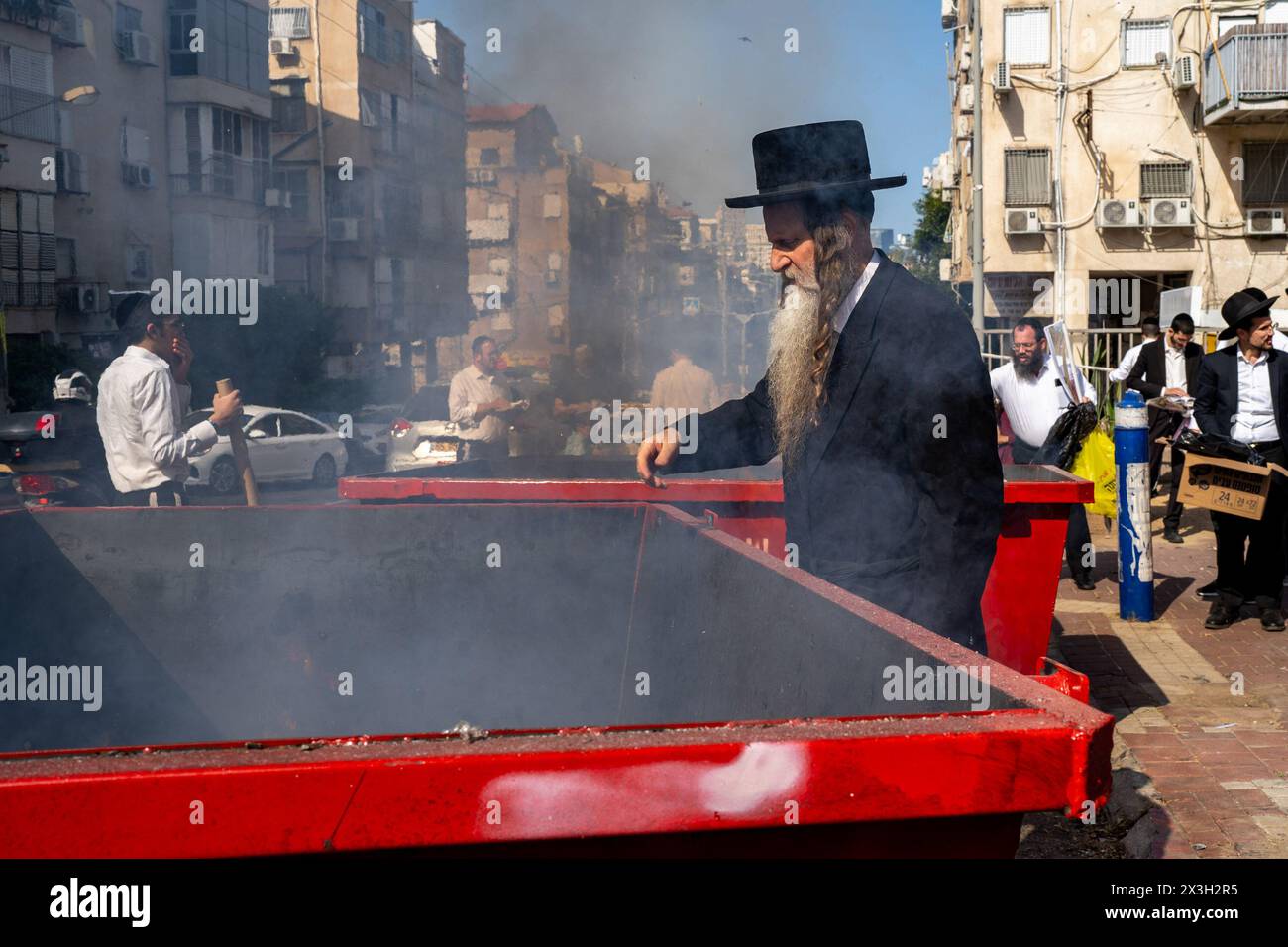 A Jewish man throws leaven into the fire during the Biur Chametz ...