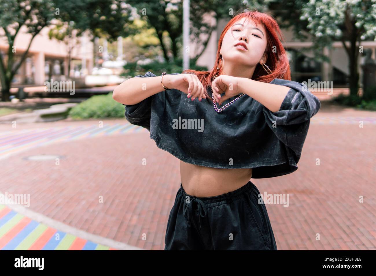 Joyful Korean woman dancing freely on a colorful urban pavement Stock ...