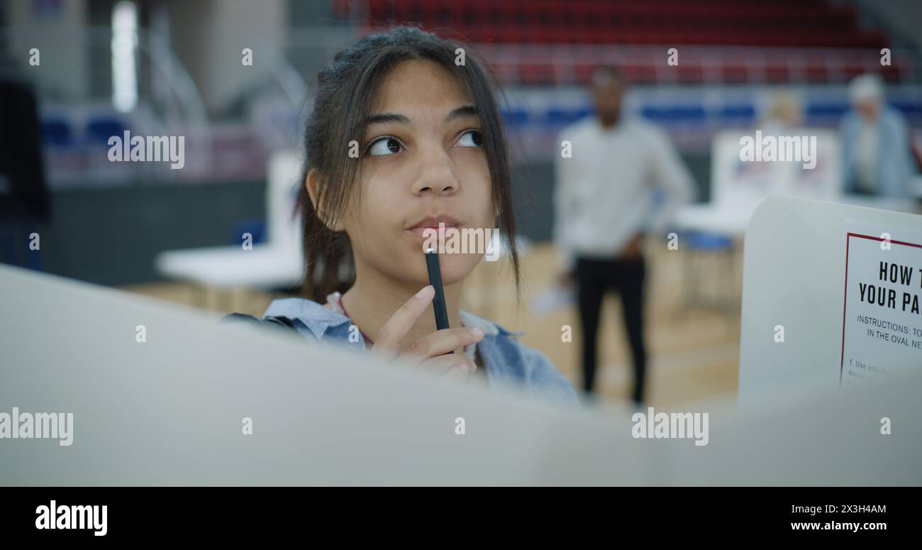 African American young female voter comes to voting booth. American ...