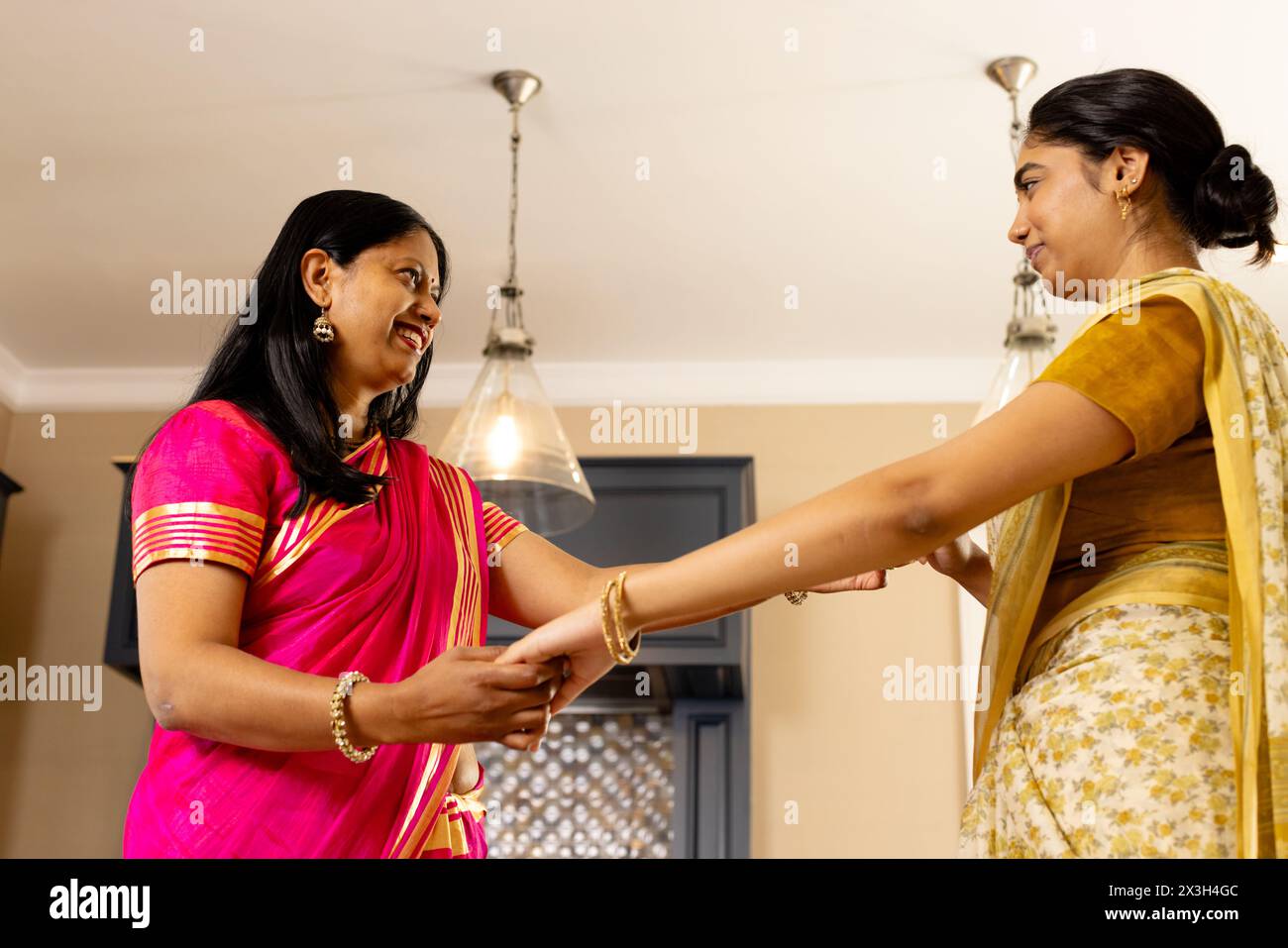 Indian mother in pink saree and teenage daughter in yellow saree ...