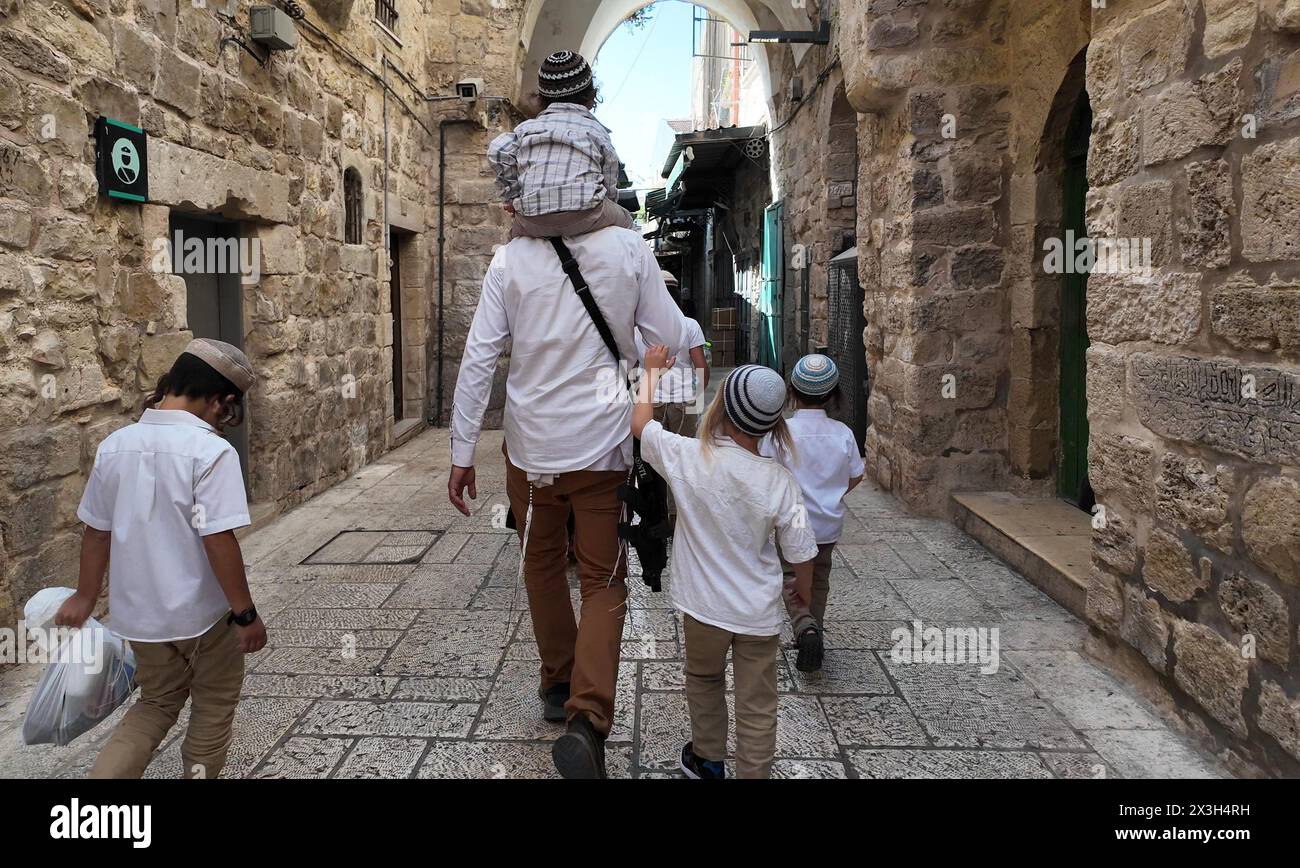 A religious Jewish settler with an assault rifle slung across his back ...